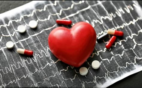 Premium Photo Red Heart With Pills On Cardiogram Cardiology Concept