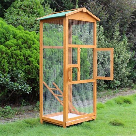 A Wooden Bird House With Two Birds On It S Roof And One In The Grass