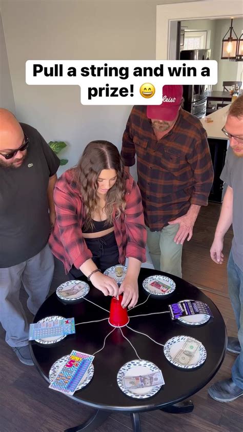 A Group Of People Standing Around A Table With Cards On It And One