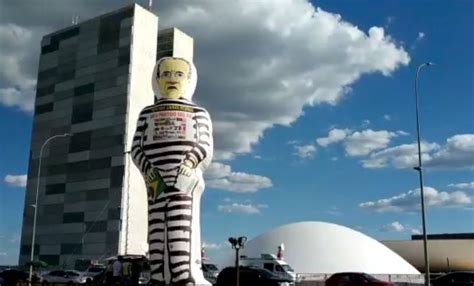 Manifestantes inflam boneco de Renan ao lado do prédio do Senado