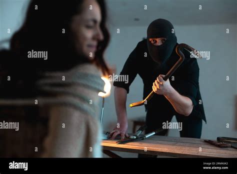 Kidnapper In Black Balaclava Threatening With A Metal Object For Woman