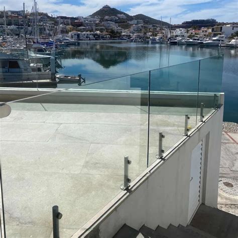 A Glass Railing On The Side Of A Building Overlooking A Body Of Water