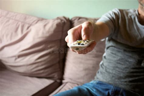Close Up Of Male Hand Holding Remote Control Man Watching TV While