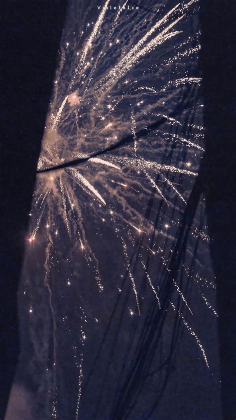 Fireworks Are Lit Up In The Night Sky Above An Umbrella With String