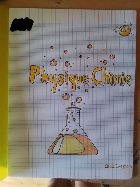 A Hand Holding Up A Notebook With The Title Physique Chimie Written On It