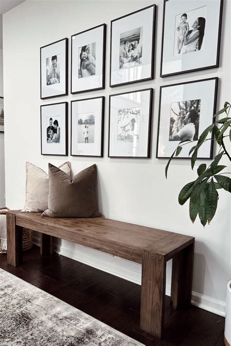 A Wooden Bench Sitting In Front Of A Wall With Pictures On The Wall