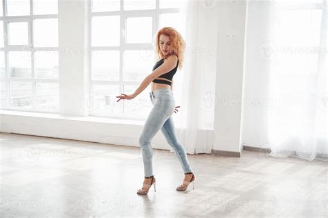 Showing Nice Dance Moves Attractive Redhead Woman Posing In The Spacey Room Near The Window