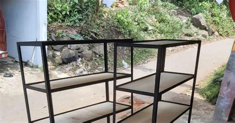 Three Metal Shelves Sitting On The Side Of A Road