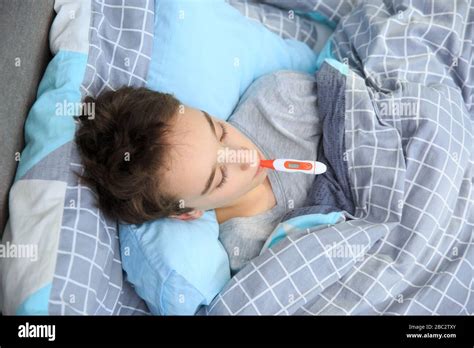 Niño enfermo acostado en la cama con fiebre y flue niño enfermo