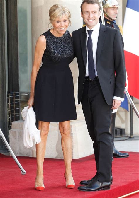 A Man And Woman Are Standing On A Red Carpet