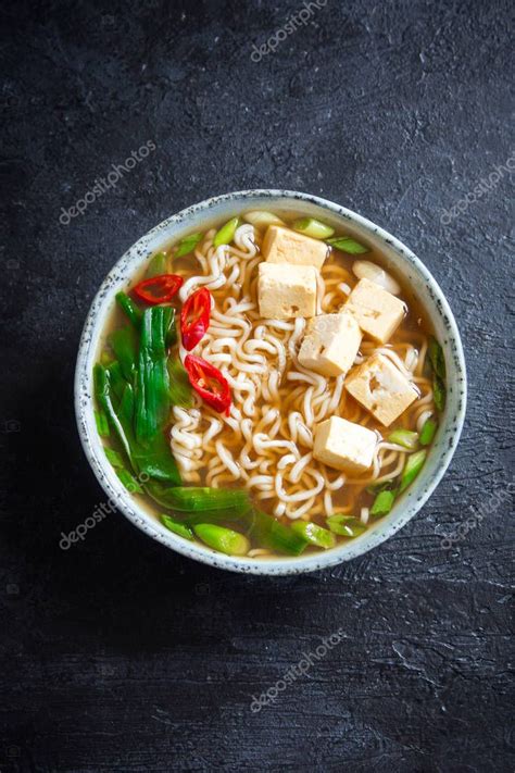 Sopa de ramen japonés con tofu sobre fondo de piedra oscura Sopa de