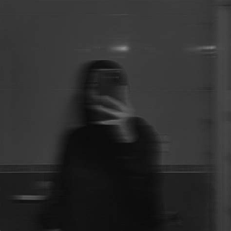A Blurry Photo Of A Woman Walking Down The Street