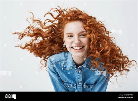 Portrait Of Beautiful Happy Cheerful Redhead Girl With Flyingcurly Hair Smiling Laughing Looking
