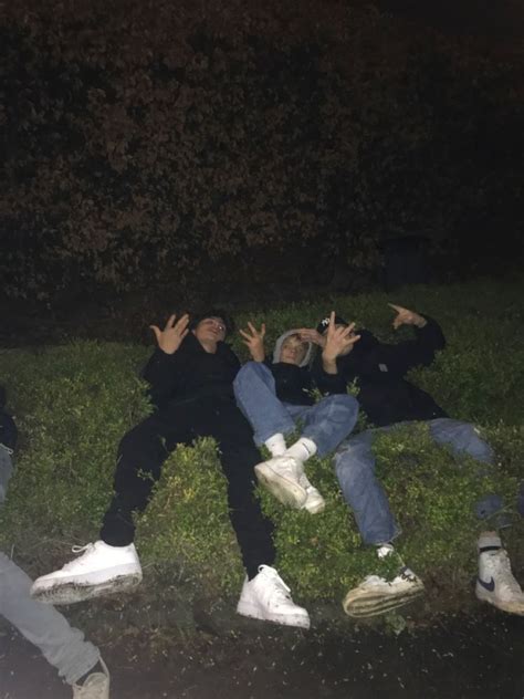 Four People Laying On The Ground With Their Hands In The Air