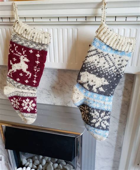 Two Knitted Christmas Stockings Hanging From A Fireplace