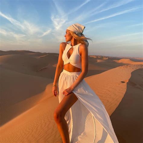 A Woman Standing In The Desert Wearing A White Dress