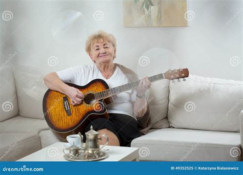 Ältere Frau Welche Gitarre Spielt Stockbild Bild von raum