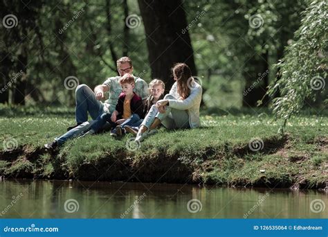 Les Parents Avec Des Enfants S Asseyant Sur L Herbe Dans La Ville Se