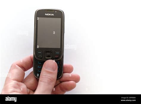 Viejo bien utilizado teléfono celular tonto nokia 6303 ci en una mano