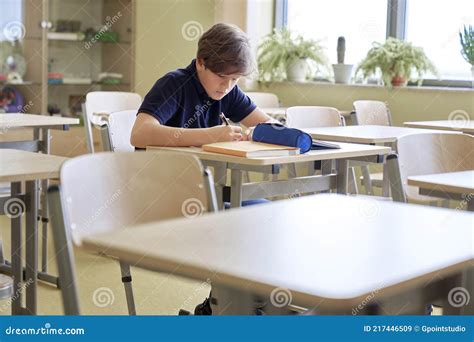 One Student Sitting And Learning Alone In Empty Classroom Stock Image