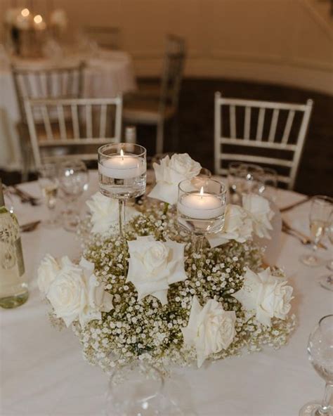 A Table With White Flowers And Candles On It
