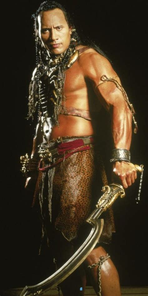 A Man Dressed In Armor And Holding Two Swords