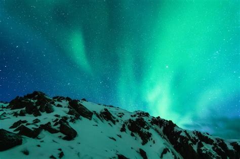 Premium Photo Aurora Borealis Above The Snow Covered Mountain Range