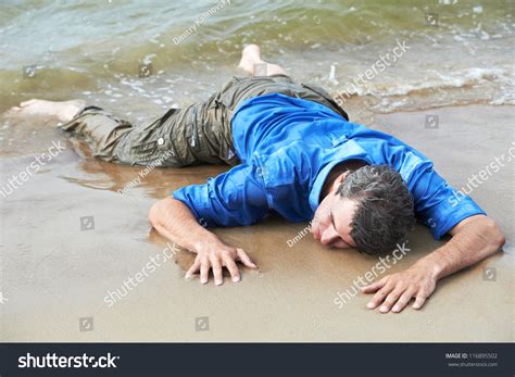 Drowned Dressed Man Lying On Sea Shore At Tide Stock Photo 116895502