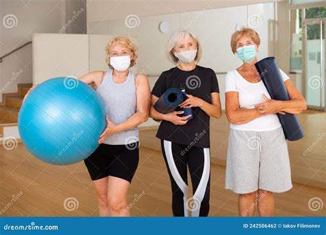 Retrato De Tres Mujeres Maduras Activas Con Máscaras Protectoras Paradas En Un Gimnasio Después