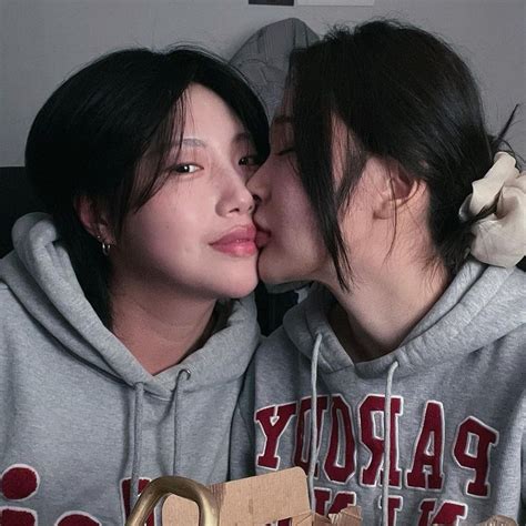 Two Young Women Kissing Each Other While Sitting On A Couch With The Word Love Spelled In Front