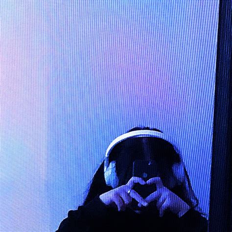 A Person Holding A Cell Phone Up To Their Face In Front Of A Blue Screen