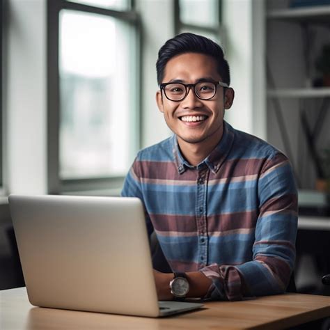 Premium AI Image A Man Sits At A Table With A Laptop And Smiling