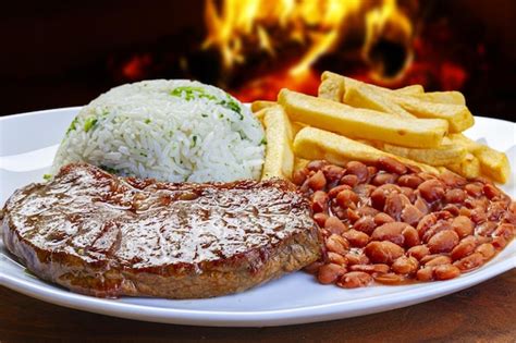 Bife grelhado arroz feijão e batata frita Foto Premium
