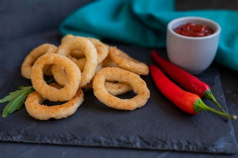 Aros de cebolla empanizados de comida rápida fritos con patatas fritas
