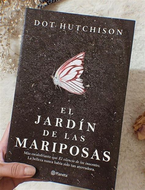 A Person Holding Up A Book With A Butterfly On It S Cover In Their Hand