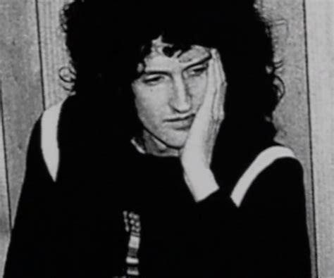 Black And White Photograph Of A Man With Long Hair Holding His Hand To