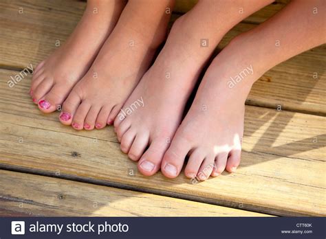 Two Pairs Of Girl S Bare Feet One With Painted Toenails Stock Photo