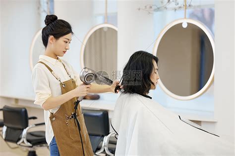 女性理发师使用吹风机给顾客吹头发高清图片下载 正版图片502380188 摄图网
