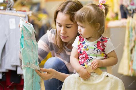 Premium Photo Attractive Mother Shows Her Daughter A Beautiful Dress
