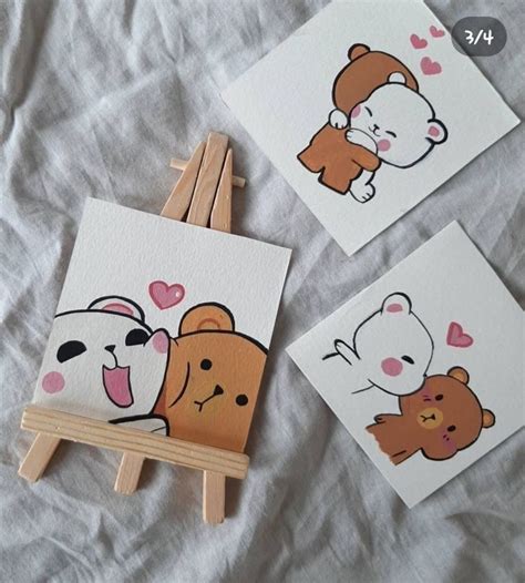 Three Small Paintings Of Bears On White Paper With Wooden Easel And