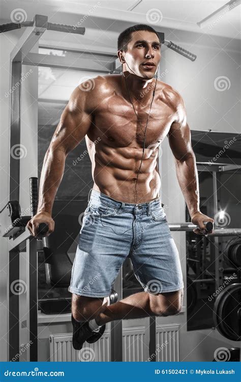 Muscular Man Working Out In Gym Doing Exercises On Parallel Bars