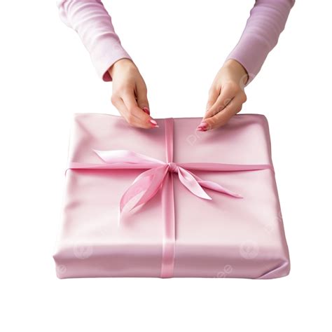 Female Hands Packing Christmas T Box In Reusable Pink Cloth In Furoshiki Style Over The Table