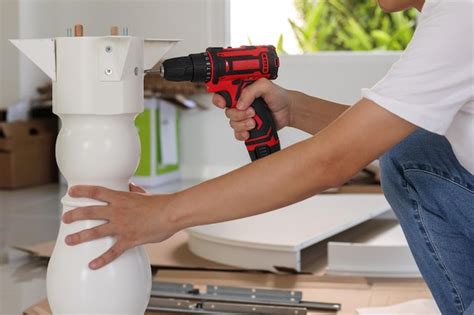 Homem montando móveis de mesa branca em casa usando chave de fenda sem