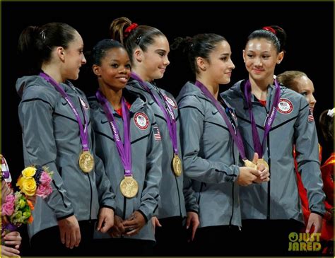 The Women S Gymnastics Team Is Posing For A Group Photo With Their Gold