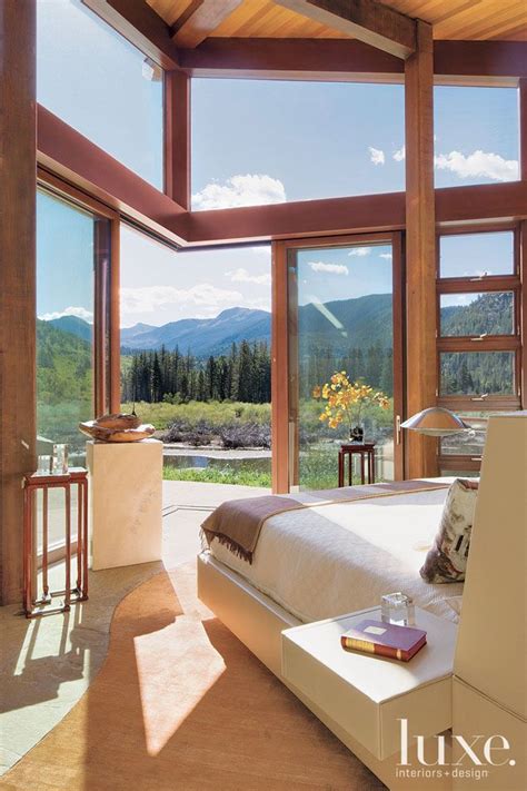 A Bed Sitting In A Bedroom Next To Large Windows