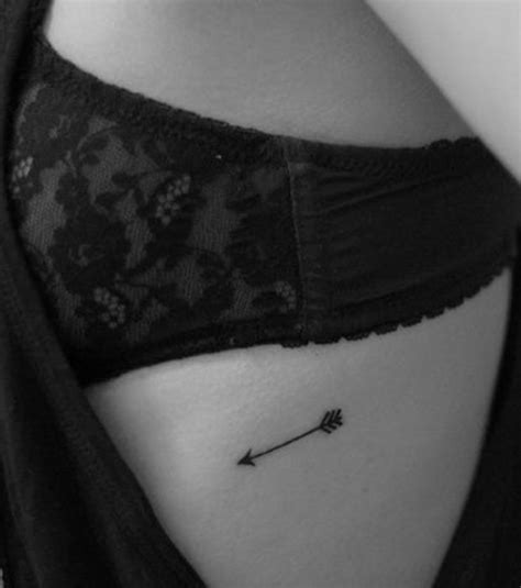 Tatouage minimaliste d une flèche sur les côtes Tatouages