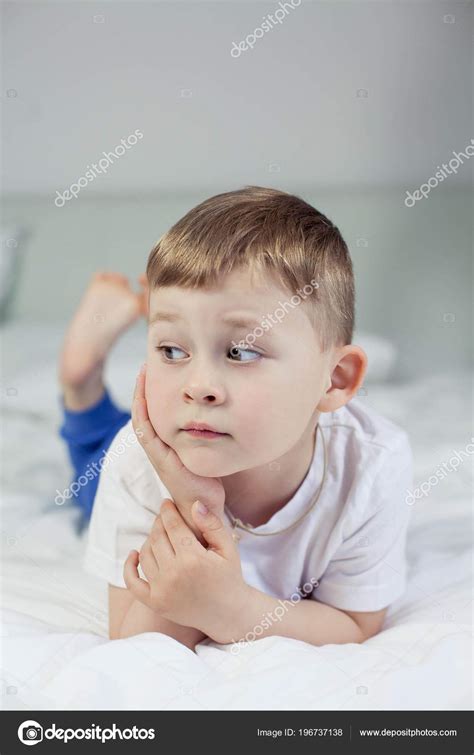 Mignon petit garçon est allongé sur le lit Un garçon de 4 ans joue sur
