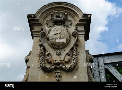 Metal Bridge With Paris Coat Of Arms Over La Seine River In Paris