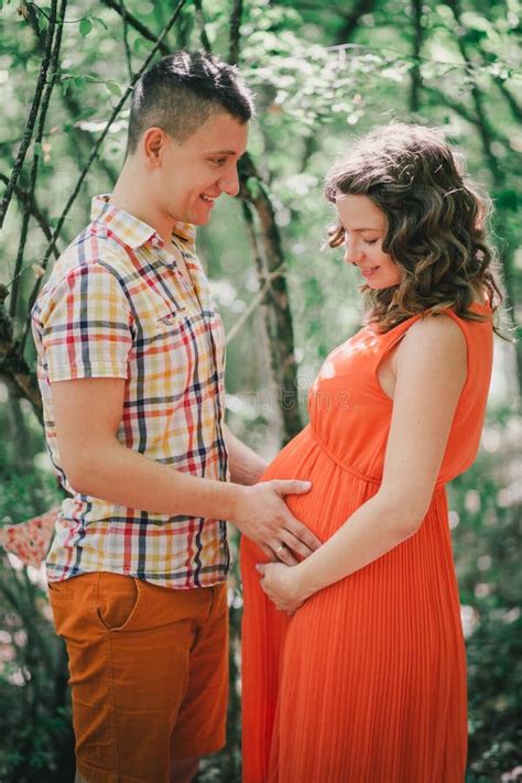 Femme Enceinte De Jeunes Avec Son Mari Tenant Des Mains Sur Son Ventre