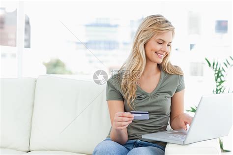女人微笑着坐着使用笔记本电脑和信用卡高清图片下载 正版图片321406586 摄图网